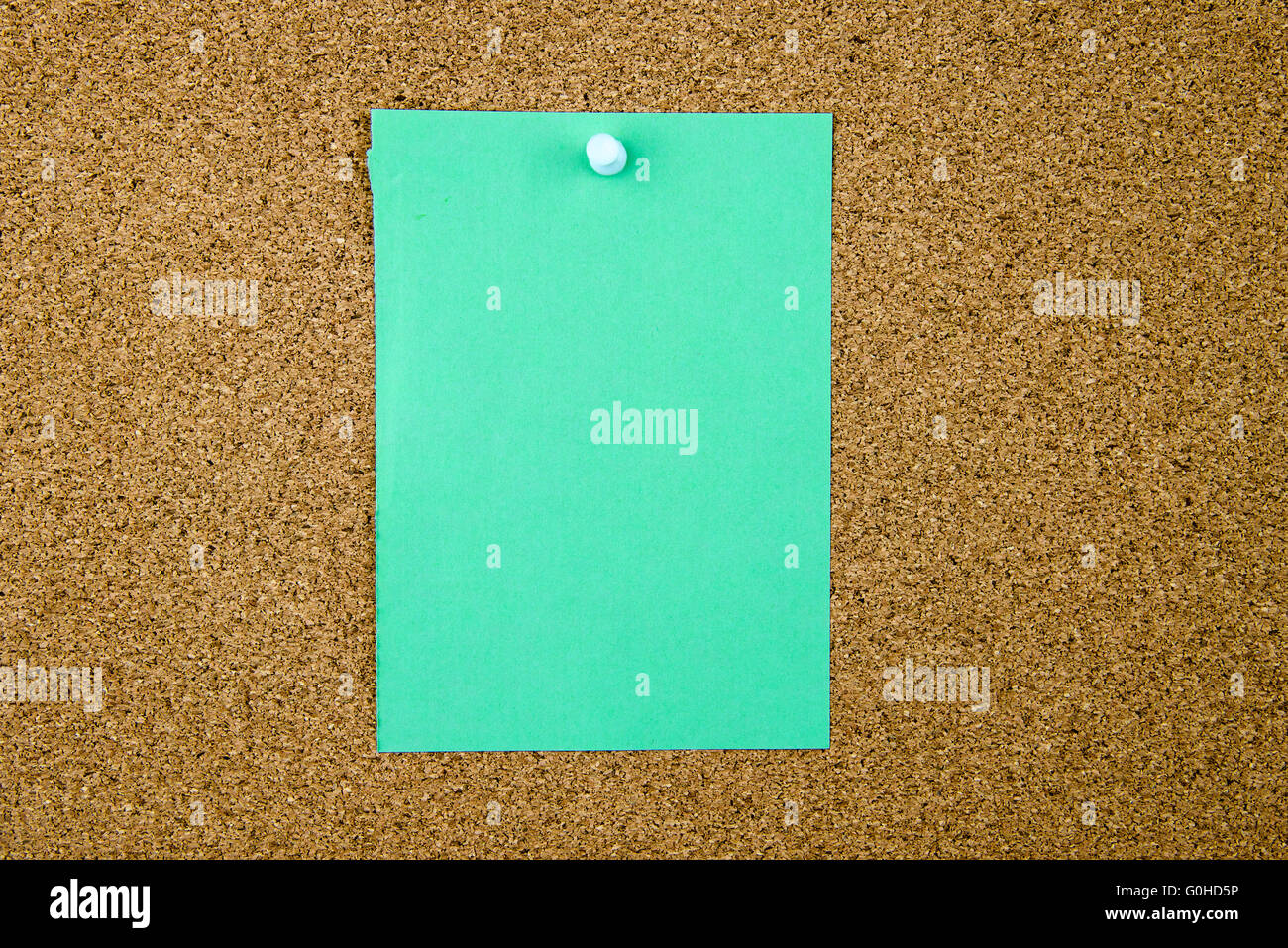 Blank turquoise paper note pinned on cork board with red thumbtack ...