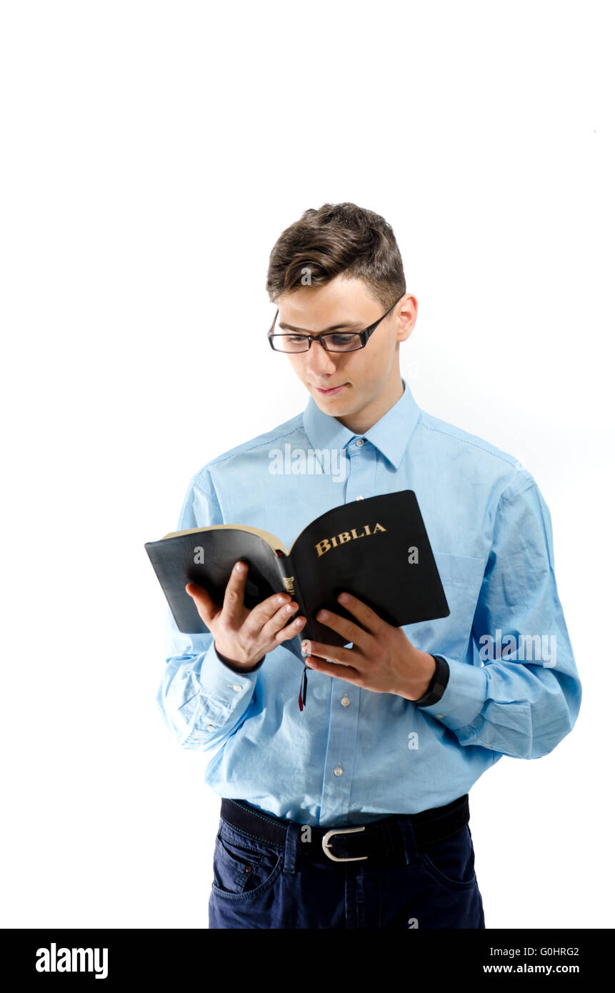 Teenager read and study from big book bible with eyeglasses isolated on ...