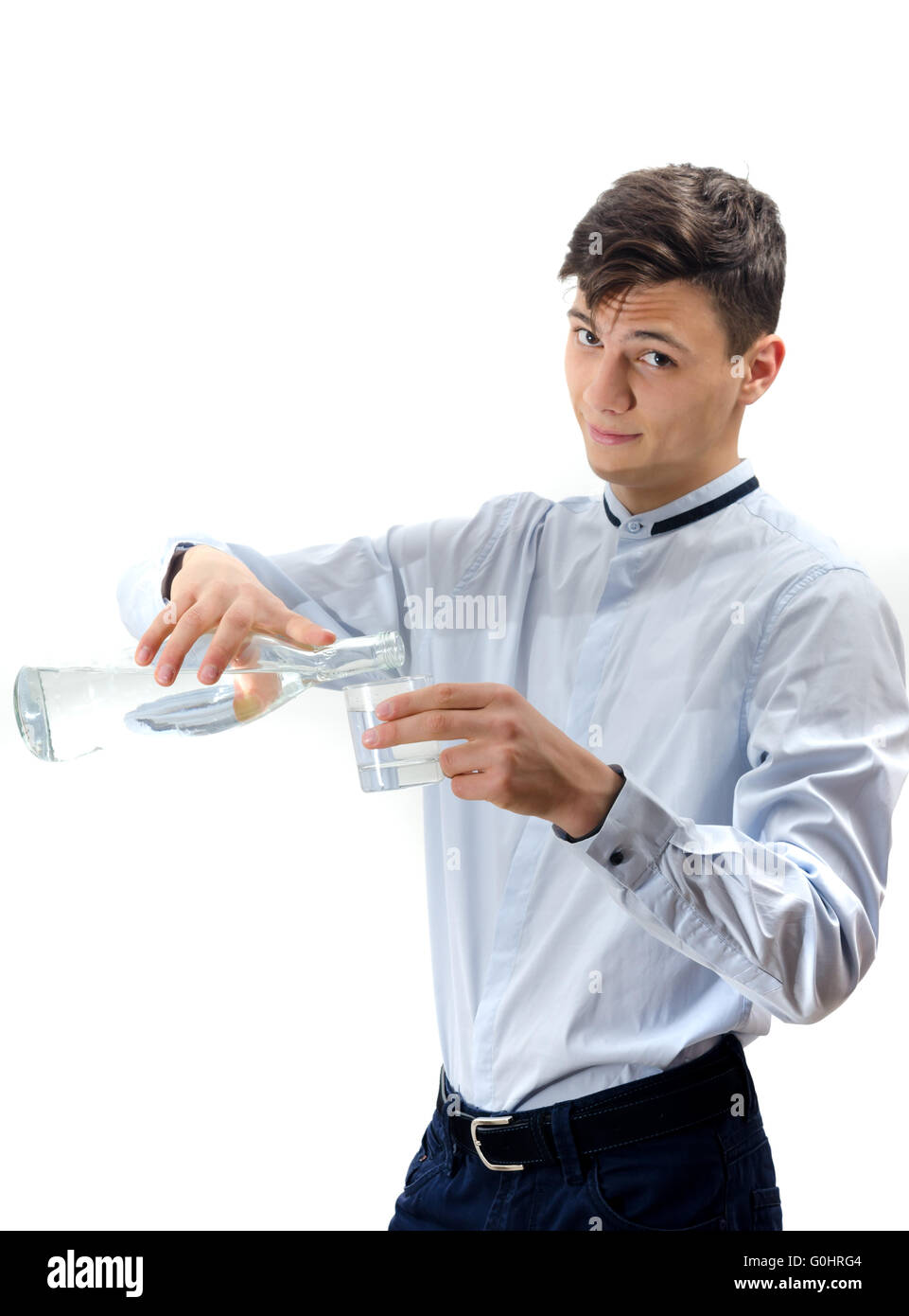Teenager waiter pouring water from glass bottle into a glass isolated on white Stock Photo - Alamy