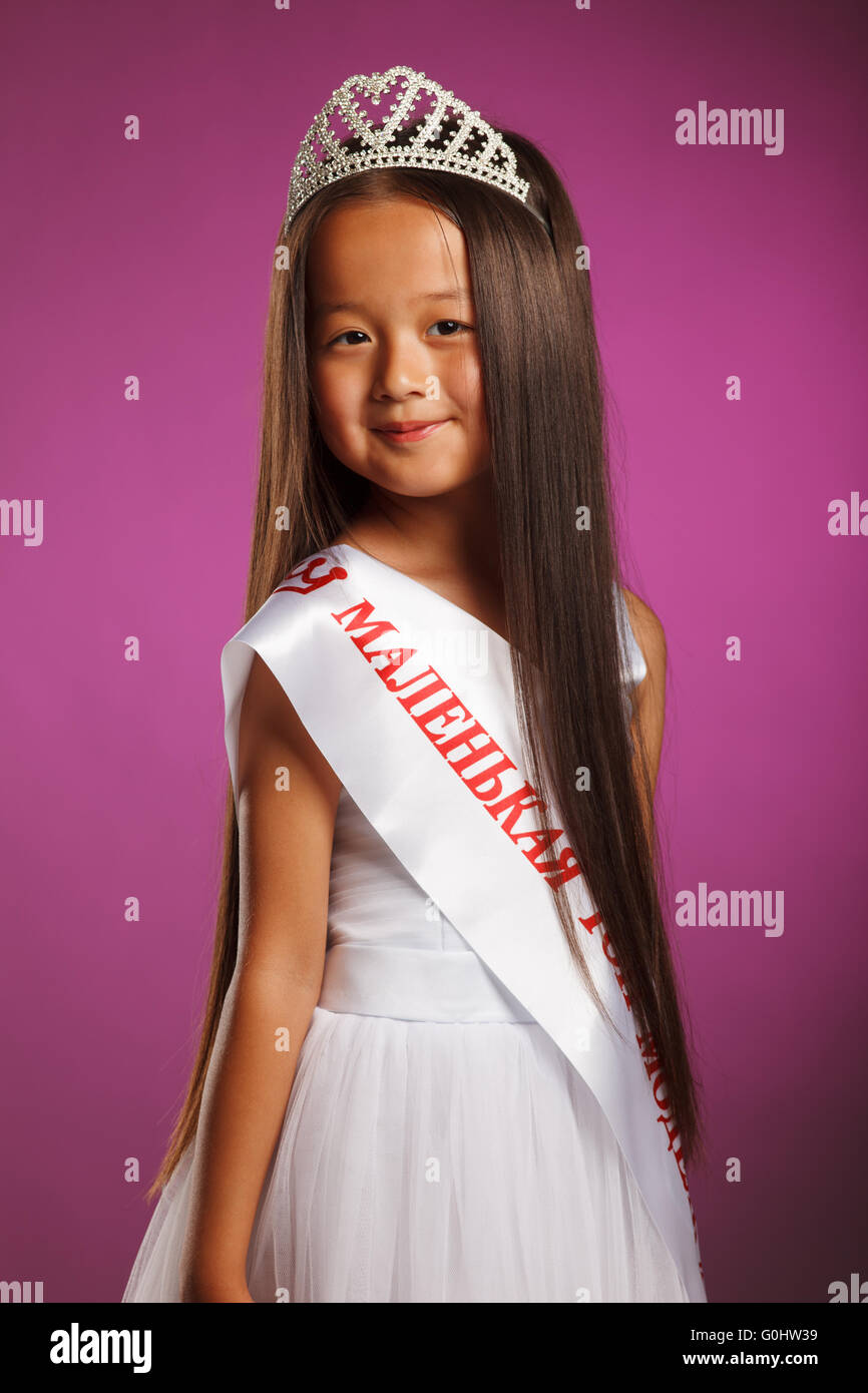 Cheerful little beauty winner posing with tiara Stock Photo - Alamy
