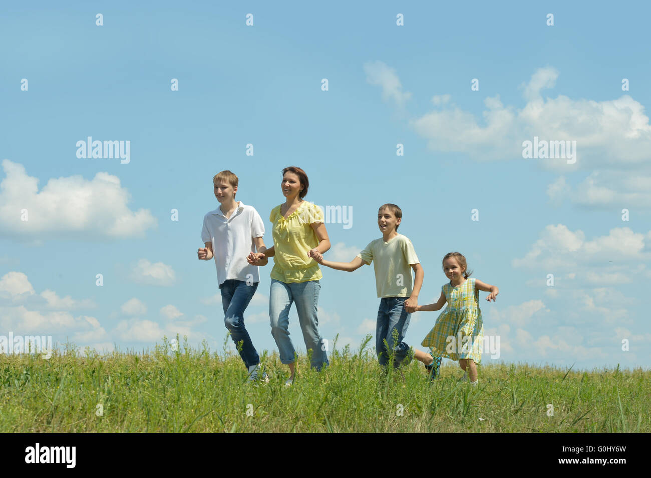 Happy family running outdoors Stock Photo - Alamy