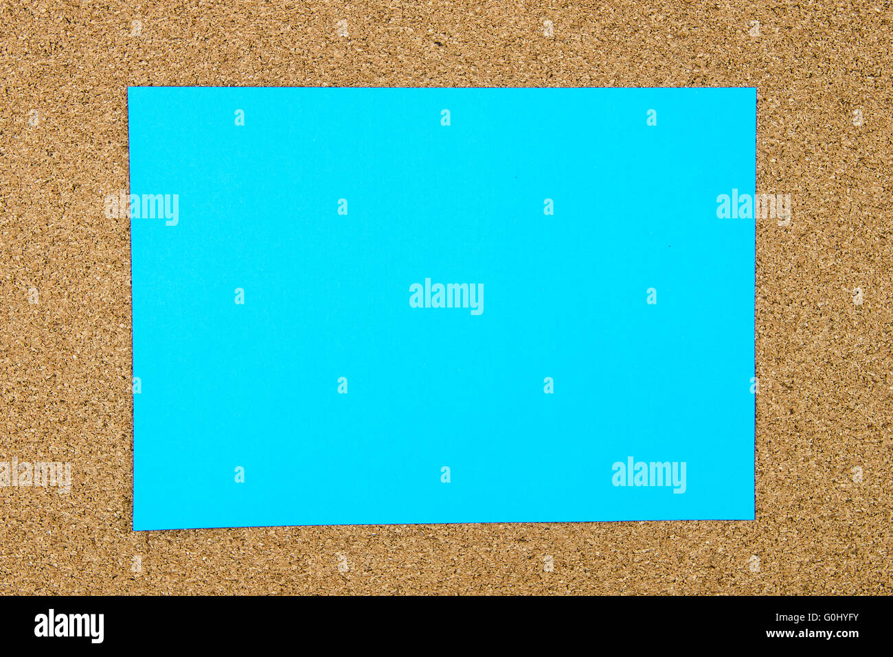 Blank turquoise paper note over cork board background, copy space ...