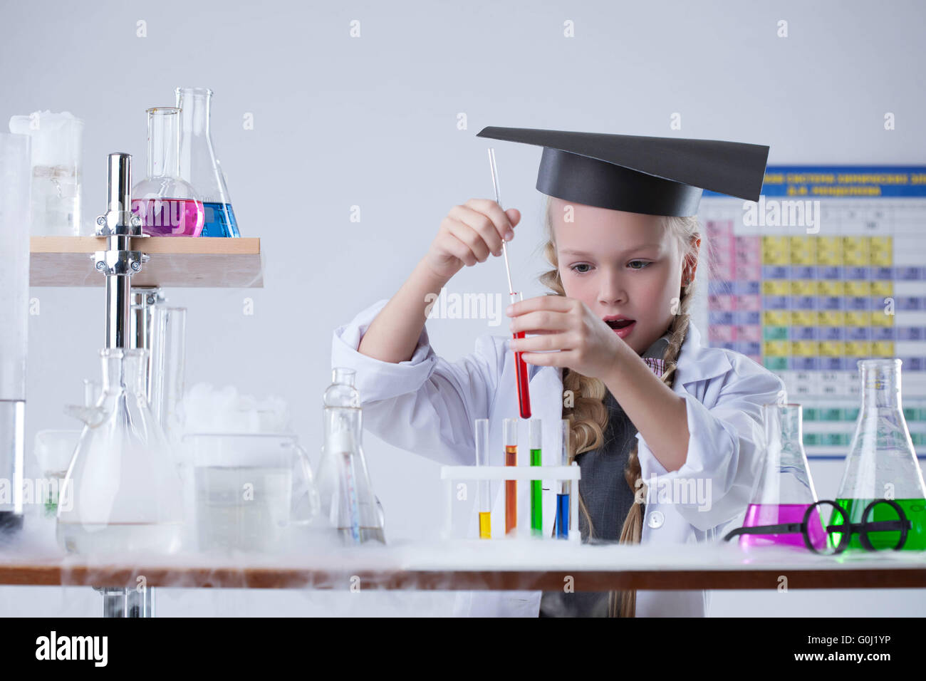 Surprised girl looking at test tubes with reagents Stock Photo - Alamy