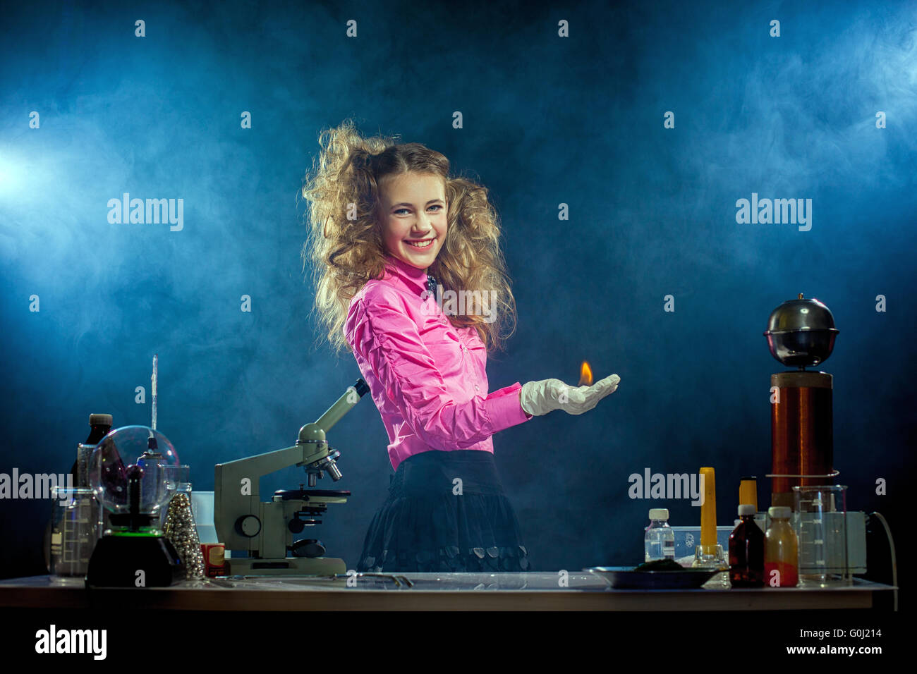Smiling pretty girl holding fire in palm of hand Stock Photo - Alamy