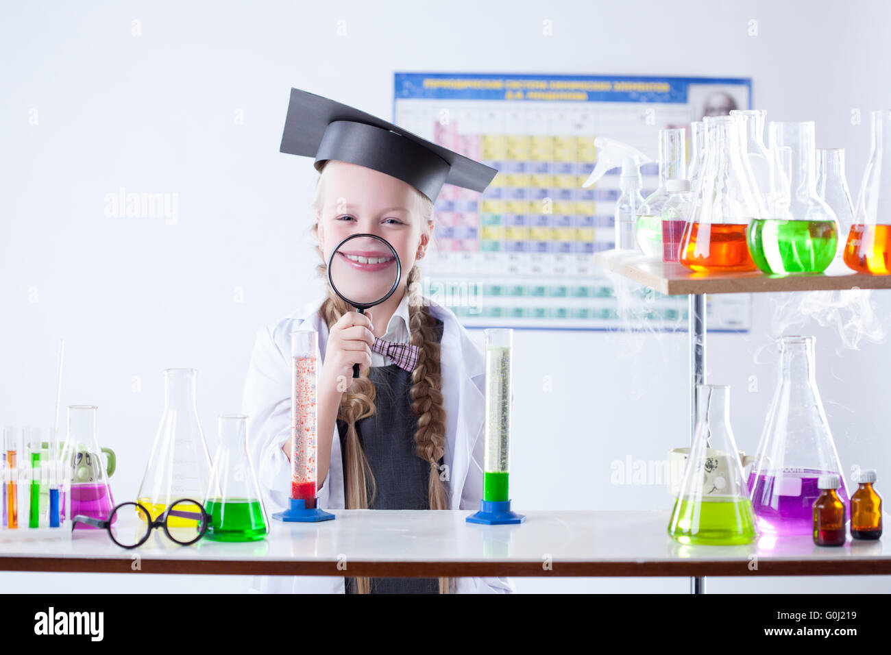 Funny little girl posing with magnifier in lab Stock Photo - Alamy