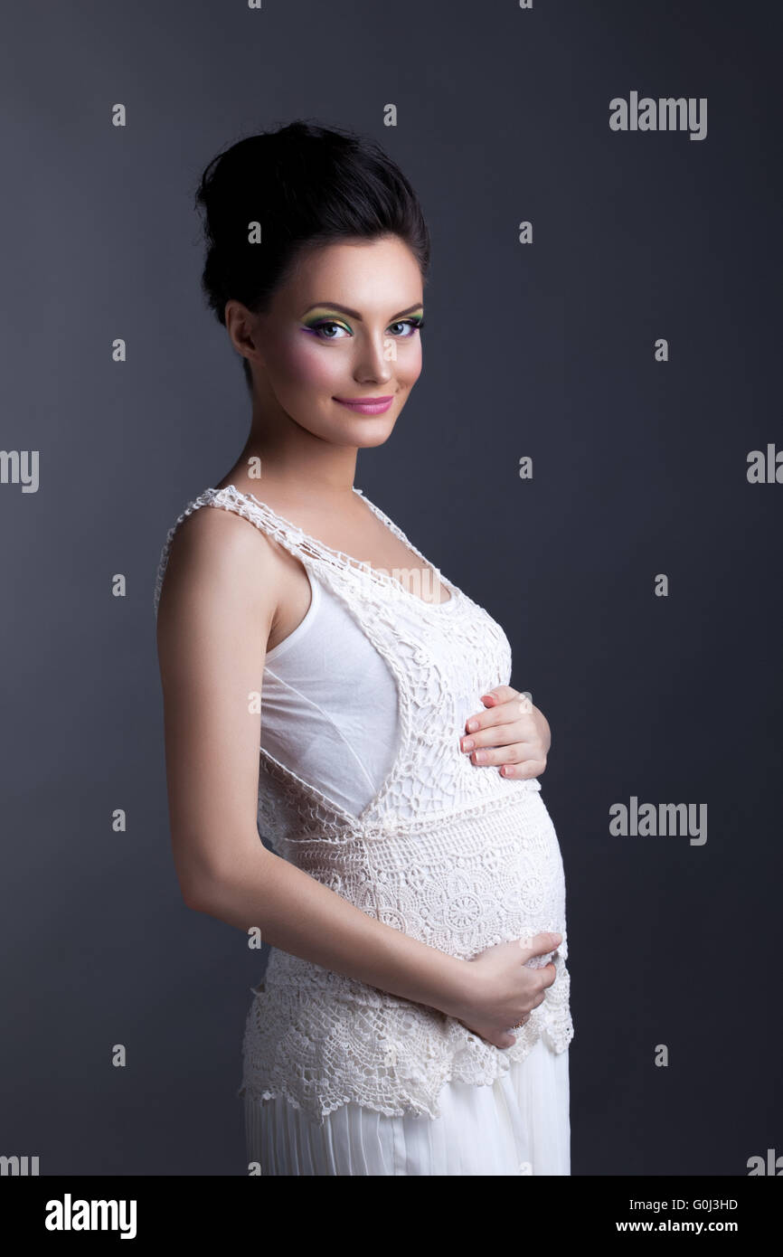 Charming expectant mother posing looking at camera Stock Photo - Alamy