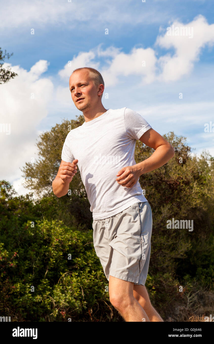athletic man runner jogging in nature outdoor Stock Photo - Alamy
