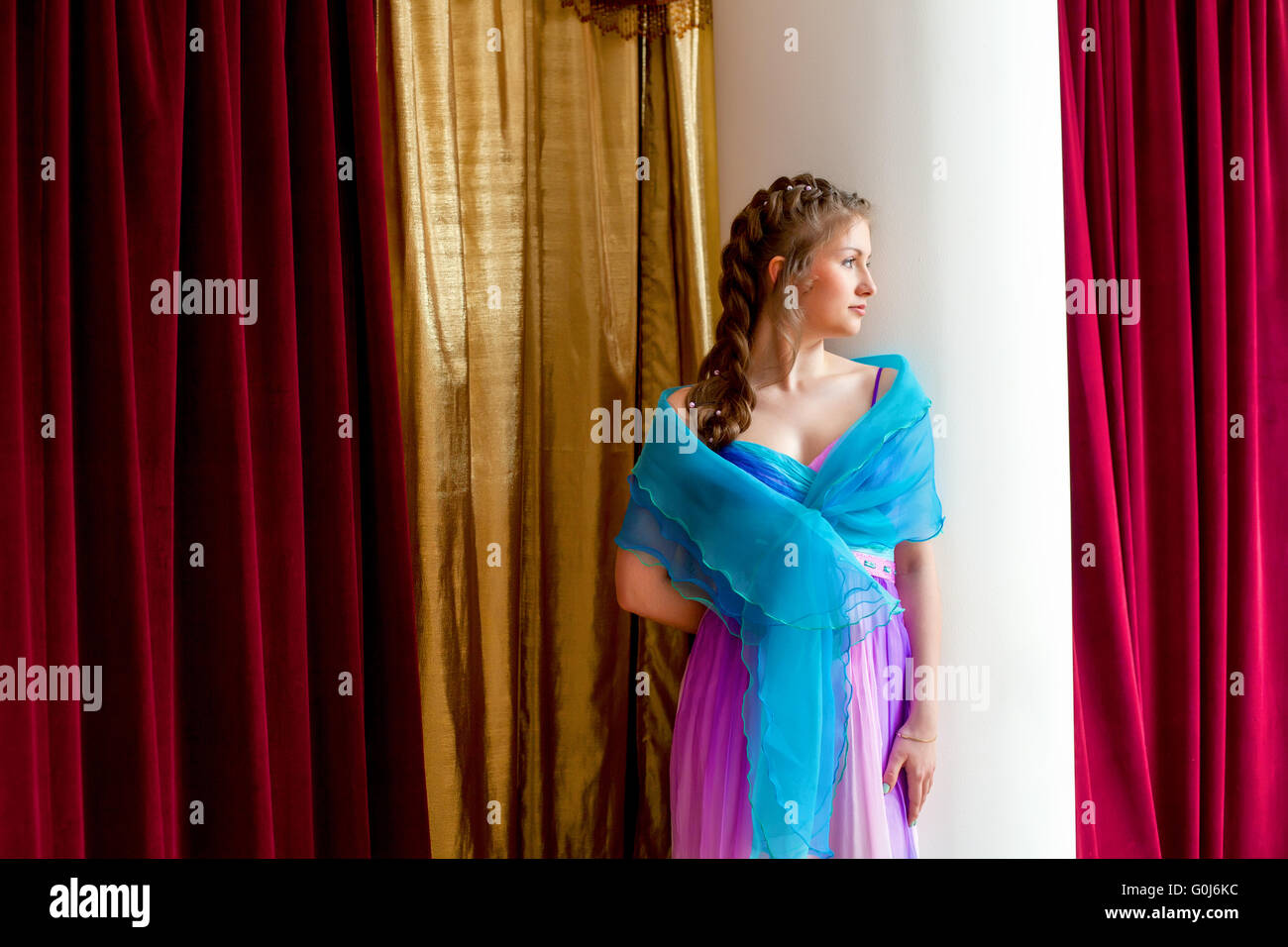 Beautiful elegant girl posing standing near column Stock Photo - Alamy