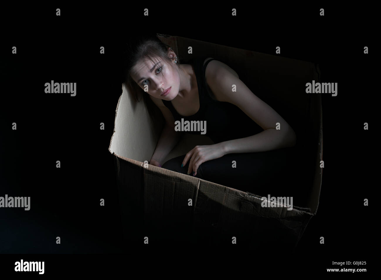 Image of sad young girl posing in cardboard box Stock Photo - Alamy
