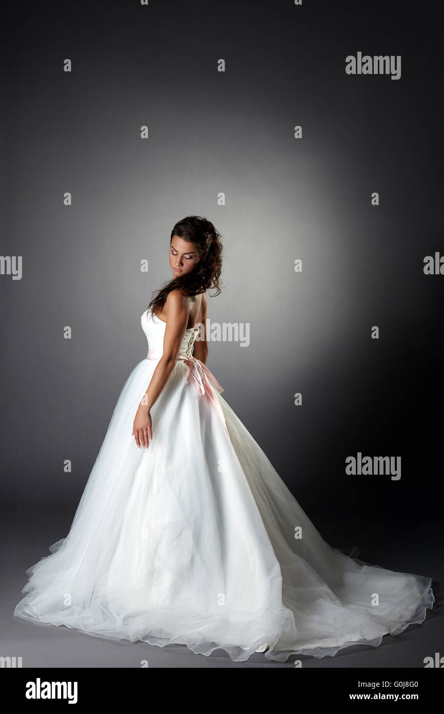 Modest bride posing in elegant dress with plume Stock Photo - Alamy
