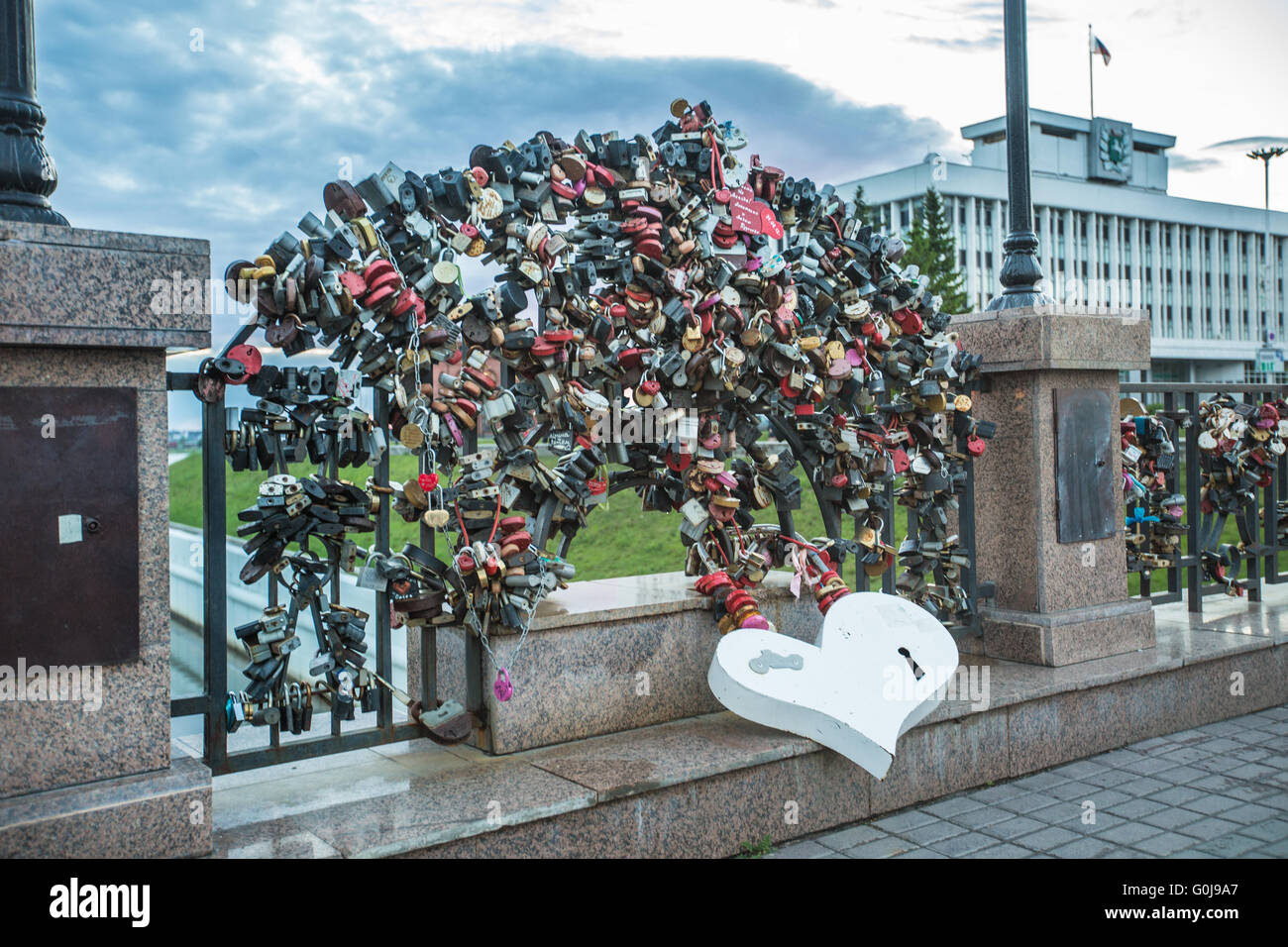 Fence building hung with locks. Wedding traditions Stock Photo - Alamy