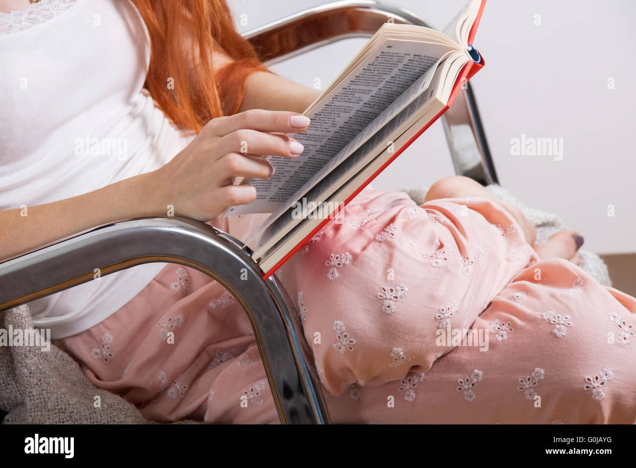Young Woman Sitting on Chair While Reading a Book Stock Photo - Alamy