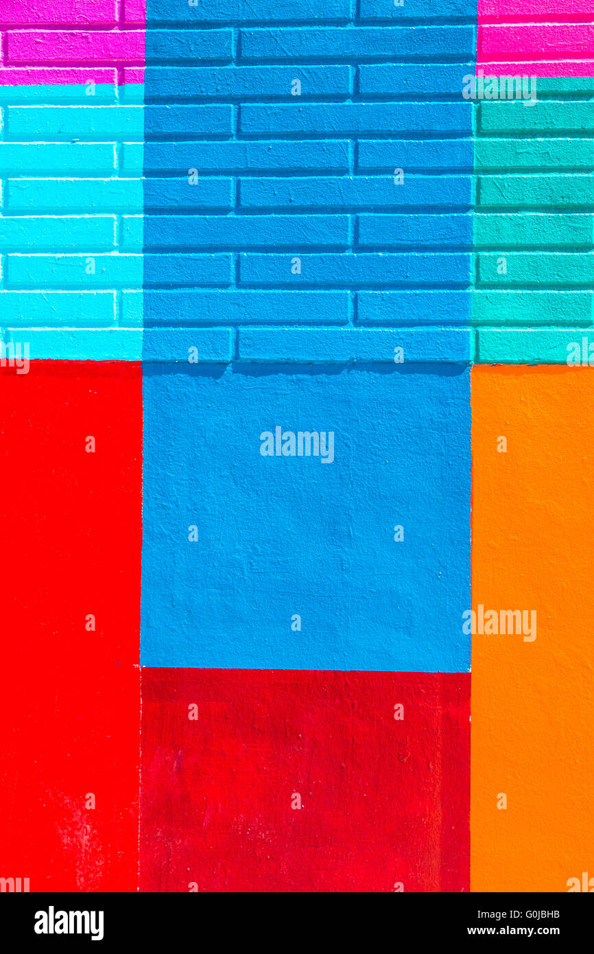 Brick and cement wall painted in vibrant colors in abstract geometric ...