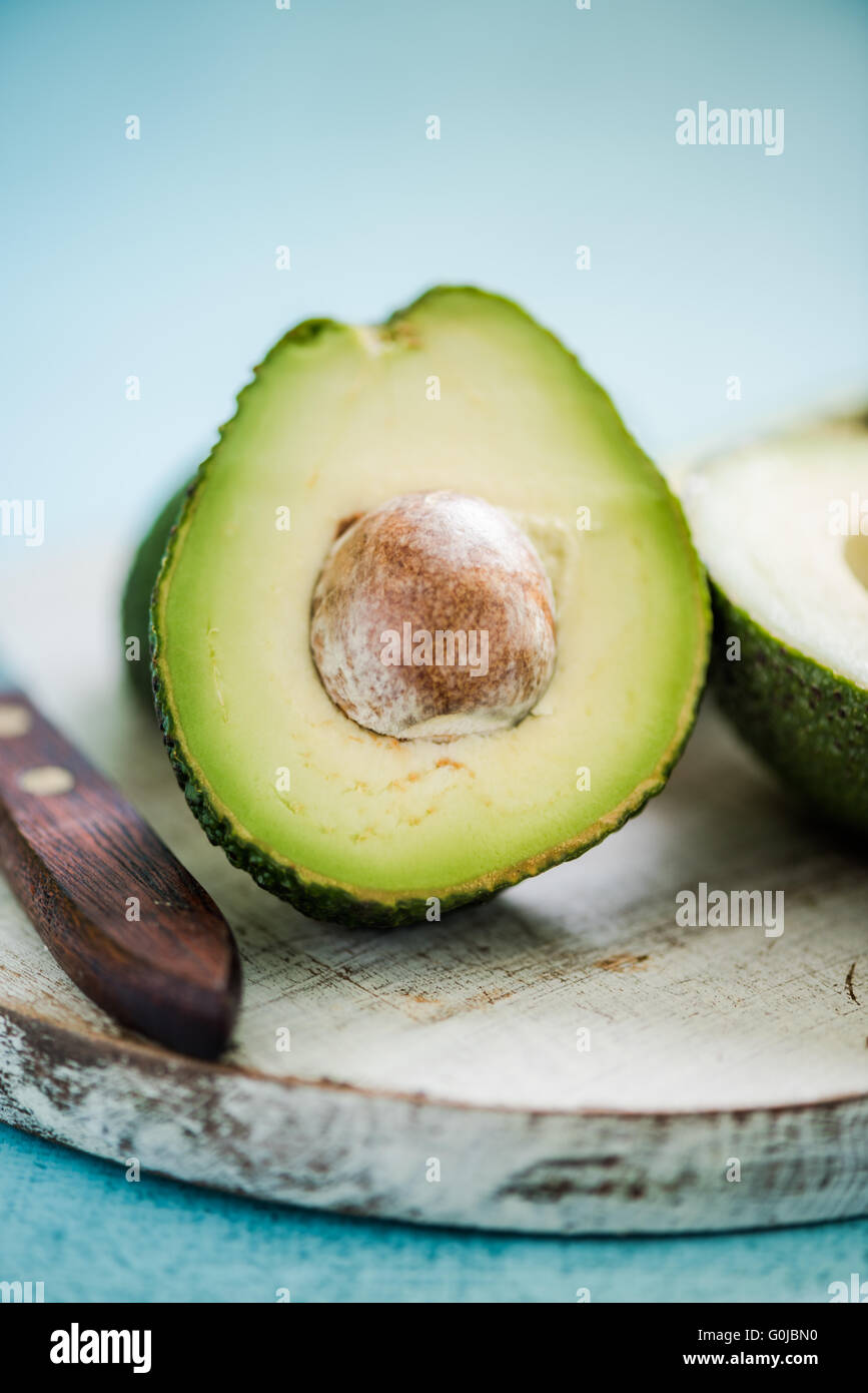 Whole and halved avocado with seed, vibrant pastel colors Stock Photo ...