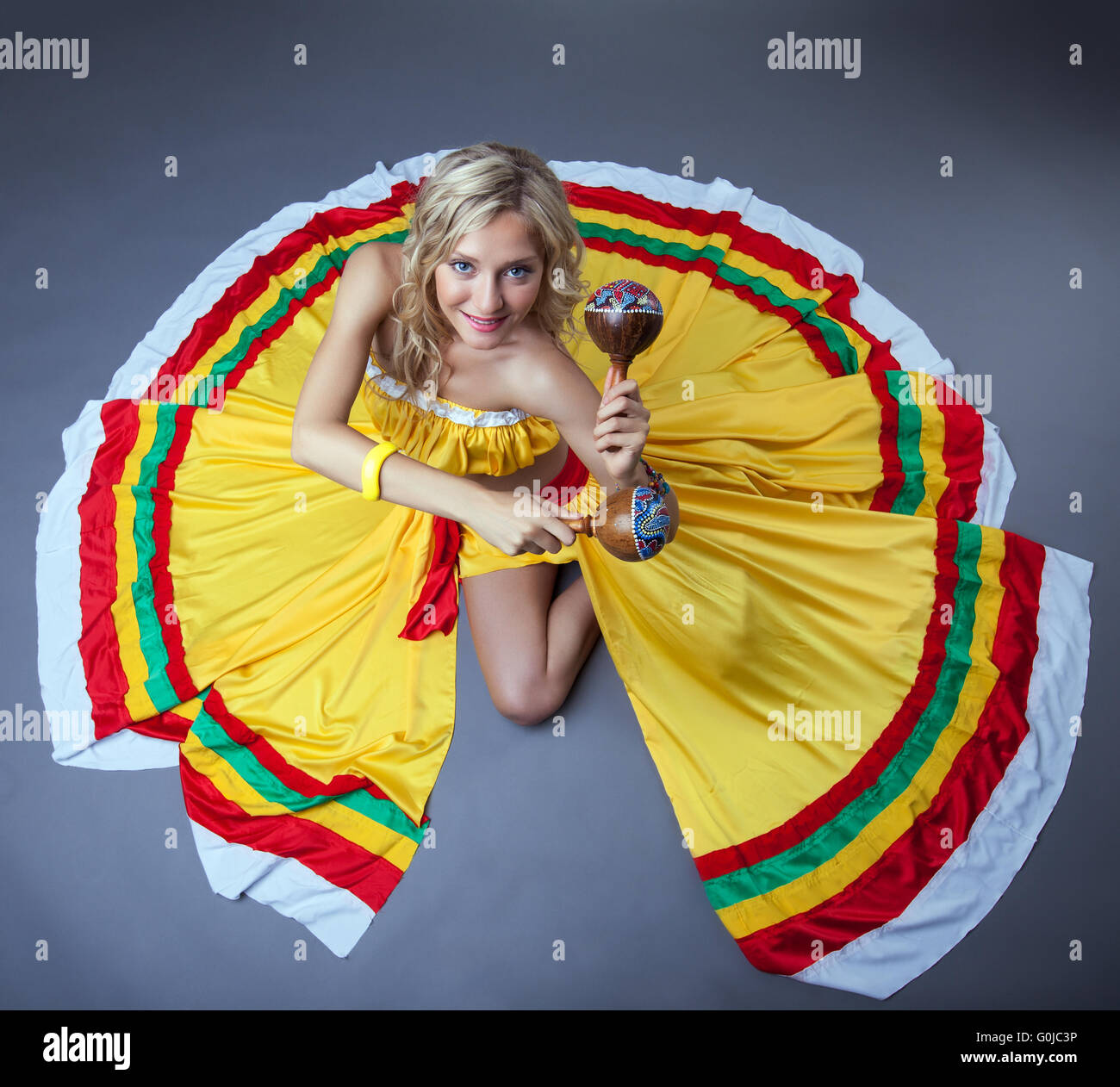 Merry Mexican dance performer posing with maracas Stock Photo - Alamy