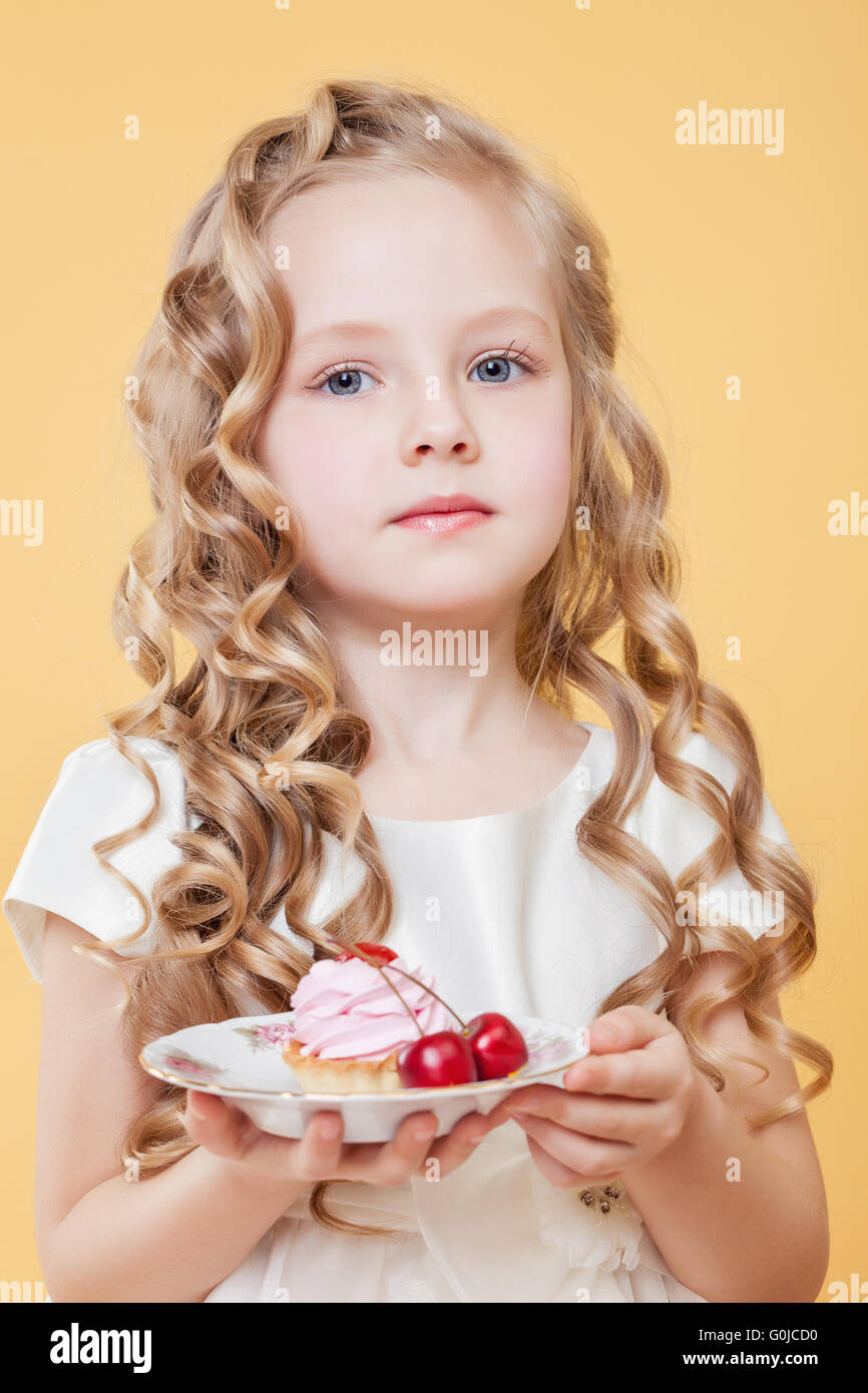 Portrait of lovely curly girl posing with cake Stock Photo - Alamy