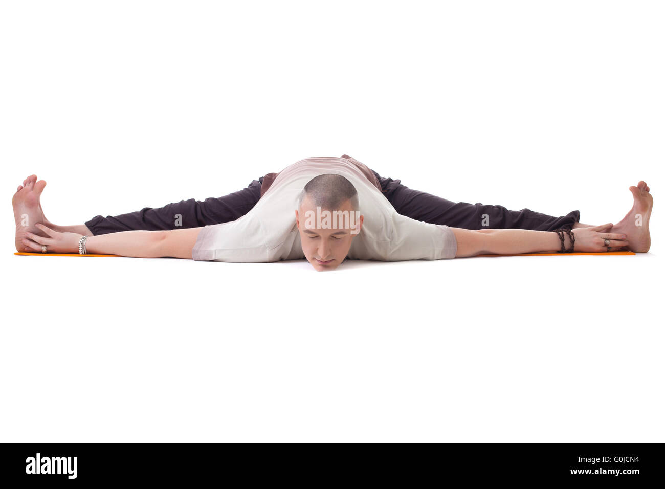 Yogi posing on split, isolated over white backdrop Stock Photo - Alamy