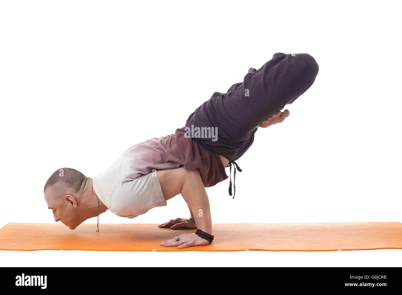 Focused athletic man posing in difficult yoga pose Stock Photo - Alamy