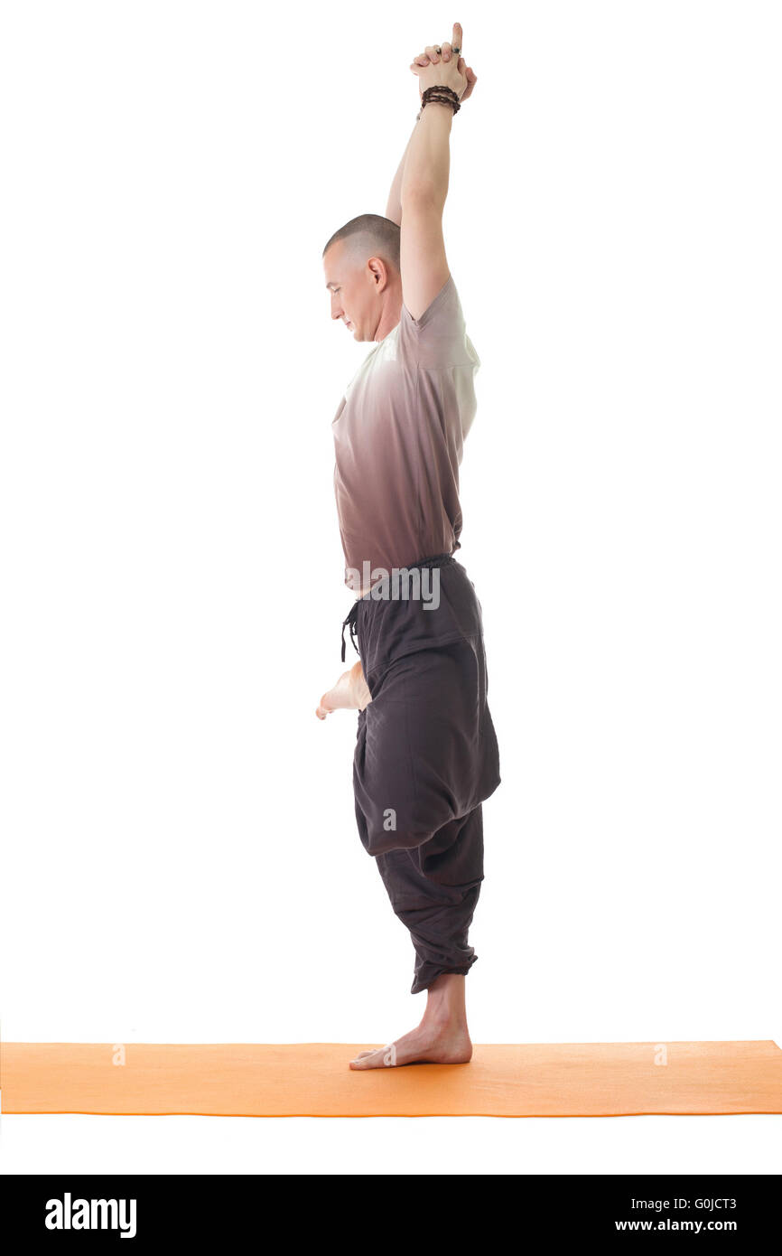Side view of relaxed yoga man standing on one leg Stock Photo - Alamy
