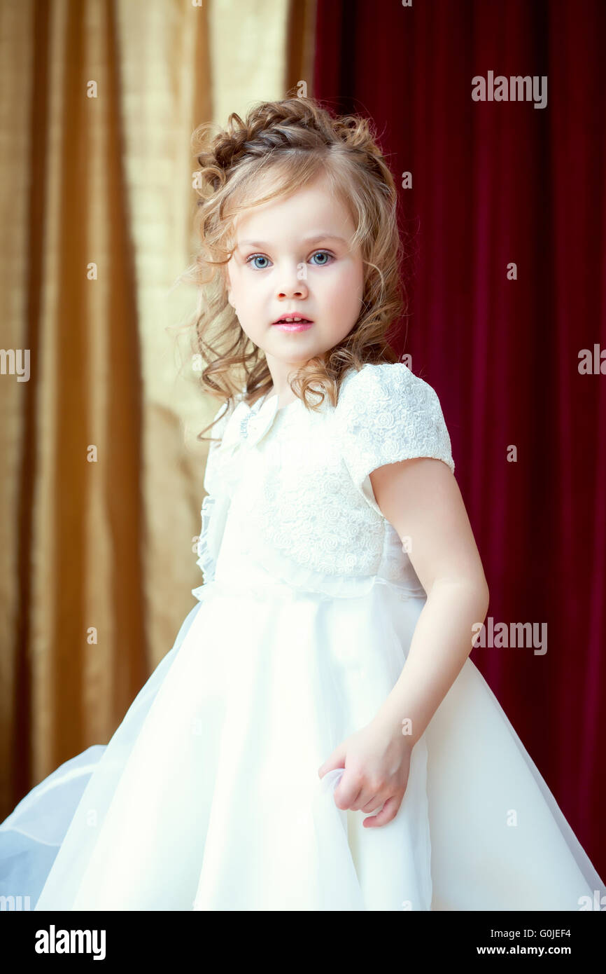 Pretty little girl posing in lush elegant dress Stock Photo - Alamy