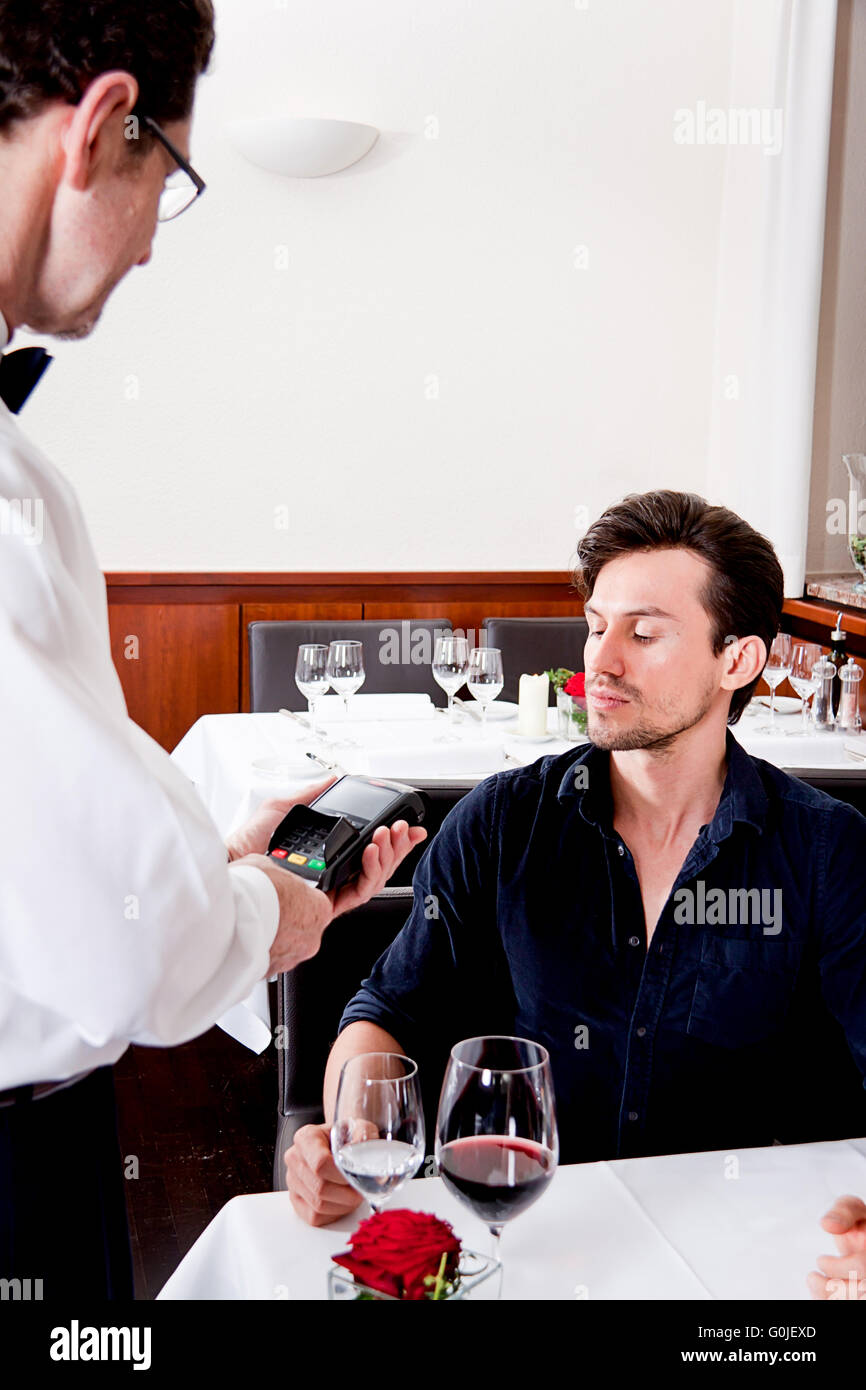 dinner in restaurant man and woman pay by credit card Stock Photo - Alamy