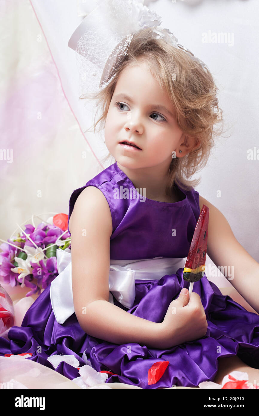 Image of fancy dressed girl posing with lollipop Stock Photo - Alamy