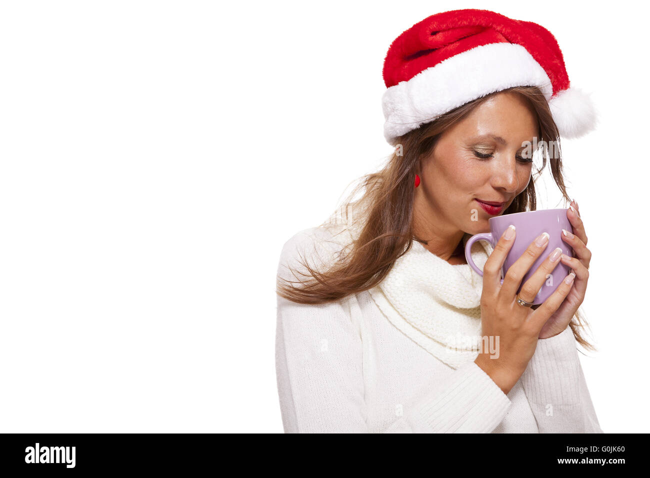 Cold young woman in a Santa hat sipping coffee tea Stock Photo - Alamy