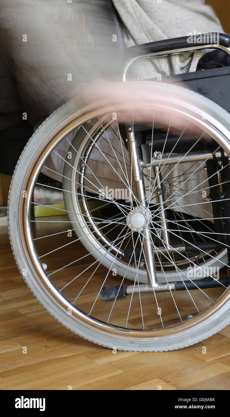 motion of hand of the young disabled in the wheel of the wheelchair ...