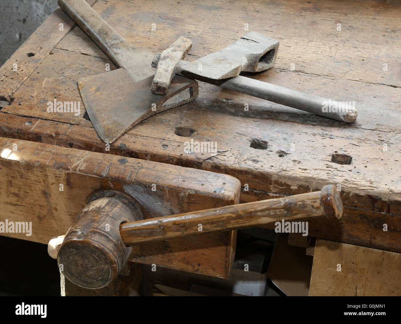 ancient tools small axe and big hammer on the old wooden workbench with ...