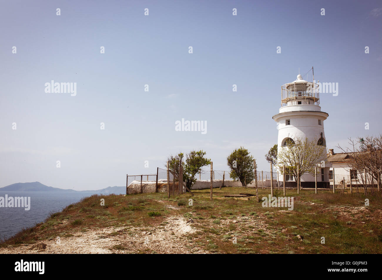 Beautiful old white lighthouse on the sea coastline. Summer seascape ...