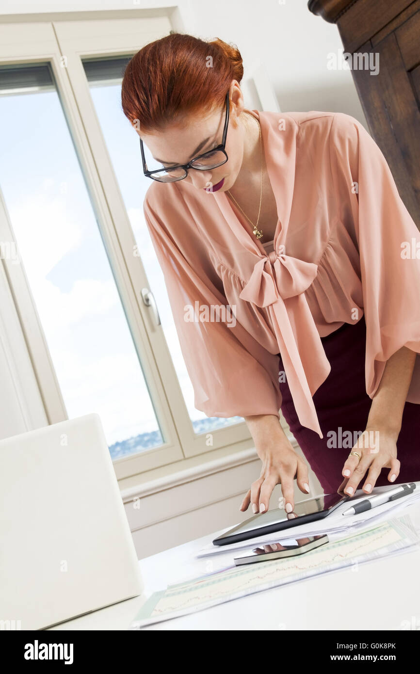 Standing Young Office Woman Writing on a Desk Stock Photo - Alamy