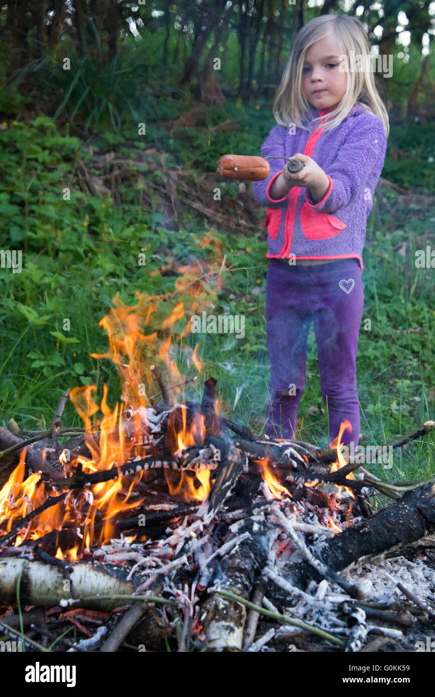 Girl Preparing and Eating Sausage Cooked On Camp Fire Stock Photo - Alamy