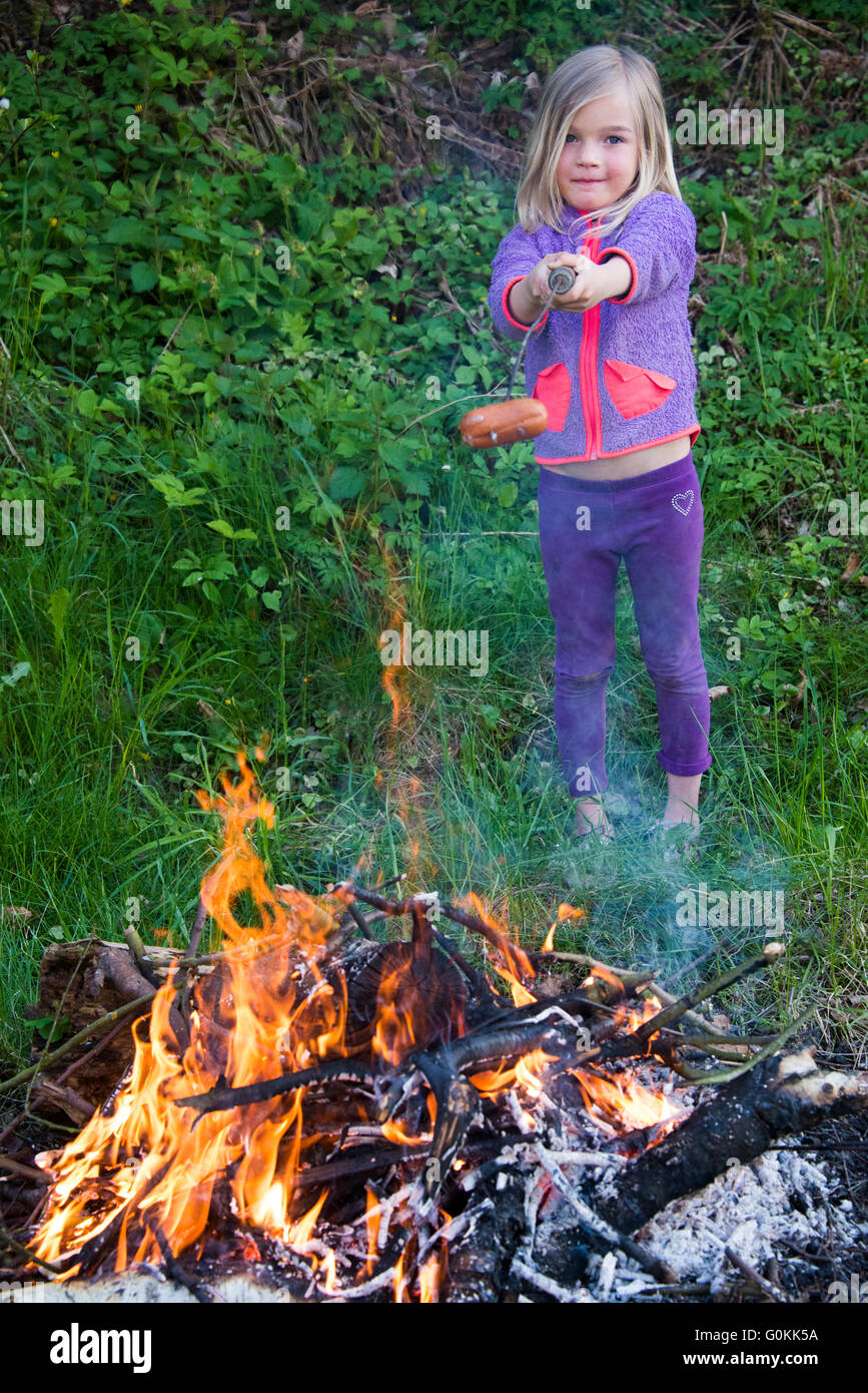 Girl Preparing and Eating Sausage Cooked On Camp Fire Stock Photo - Alamy