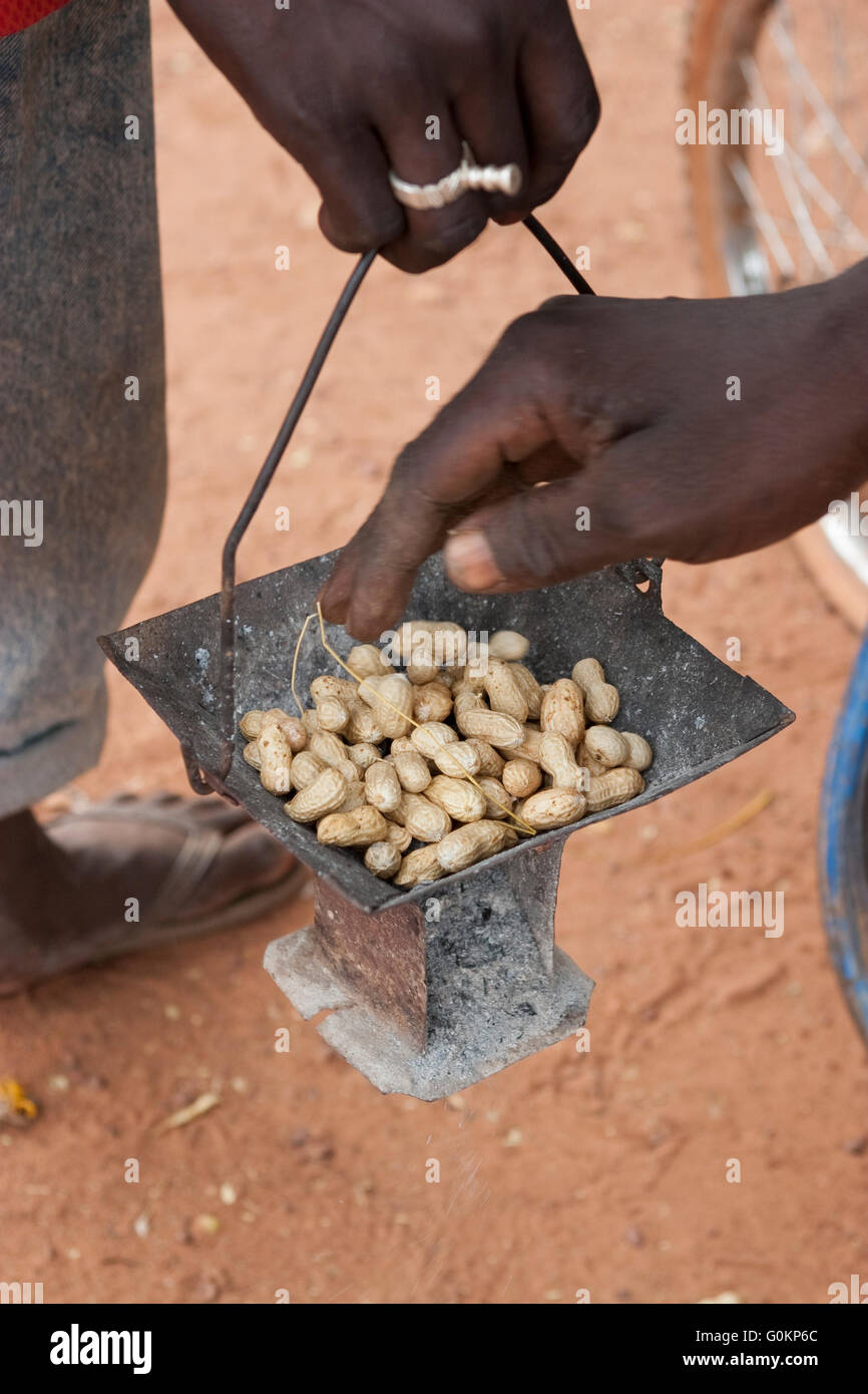 Men roasting peanuts in a portable coal pot stove in Africa Stock Photo ...