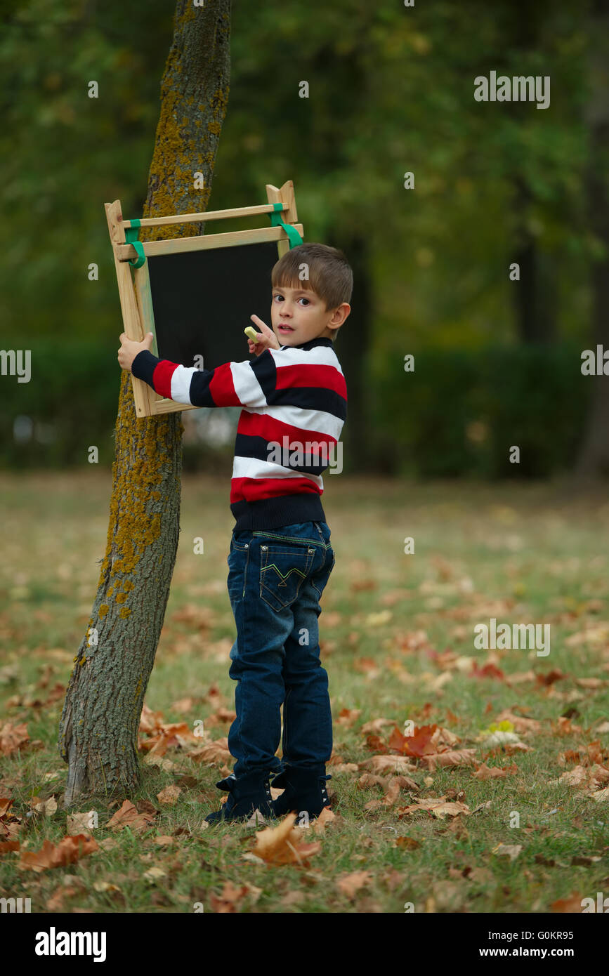 little happy boy writing on blackboard Stock Photo - Alamy