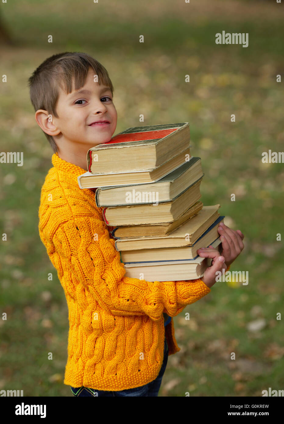 little happy boy carrying stack of books Stock Photo - Alamy