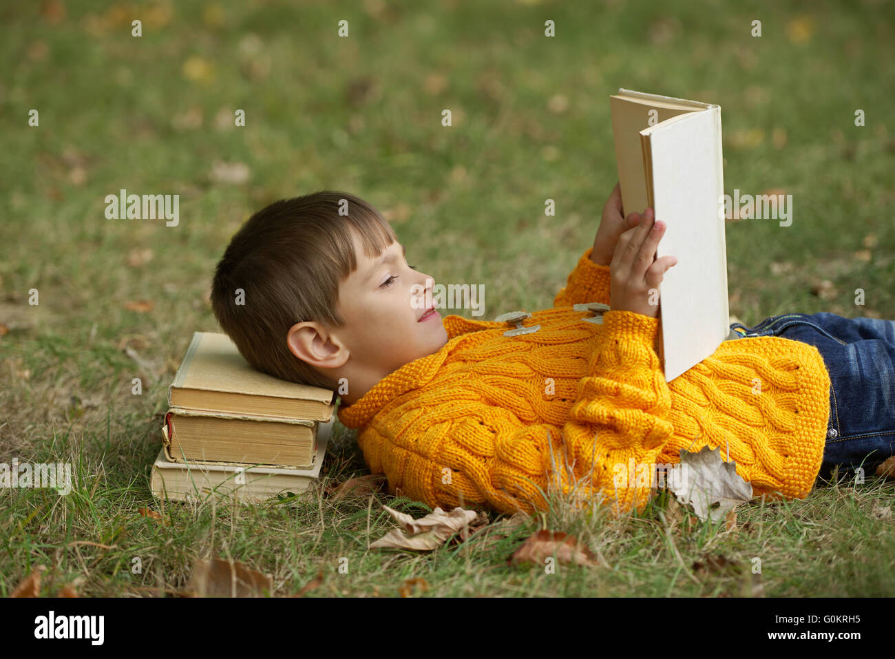 little boy sying on stack of books Stock Photo - Alamy