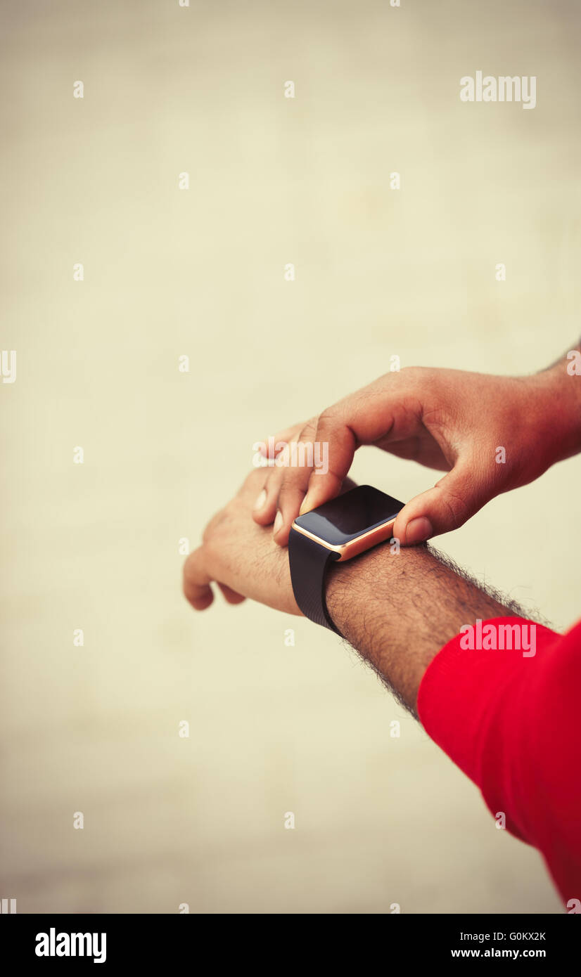 Hands of African male model using his trendy smart wrist watch. This ...