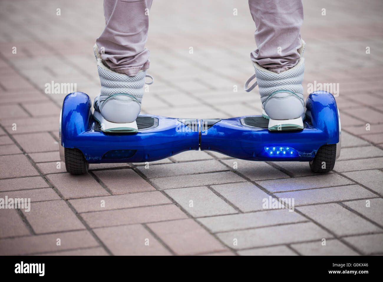 Person riding a modern blue electric mini segway or hover board ...