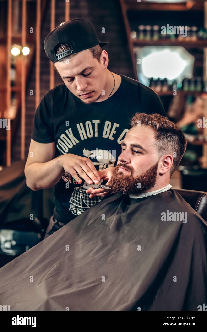 Handsome barber making beard grooming Stock Photo - Alamy