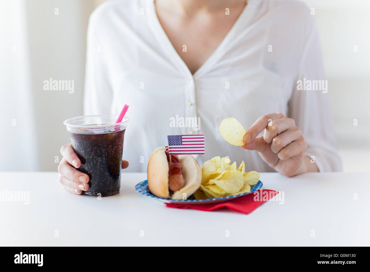 close up of woman eating chips, hot dog and cola Stock Photo - Alamy