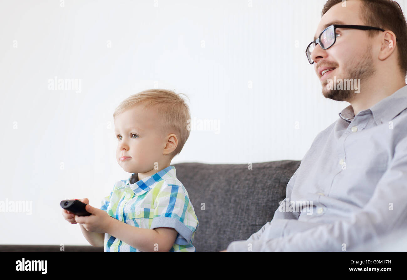 father and son with remote watching tv at home Stock Photo - Alamy