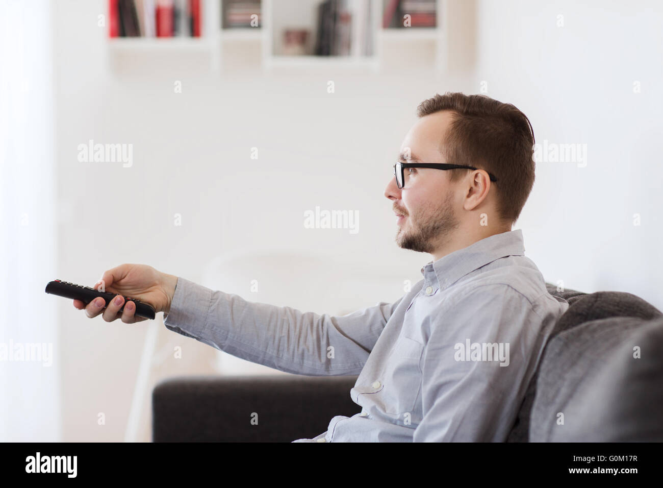 smiling man with tv remote control at home Stock Photo - Alamy