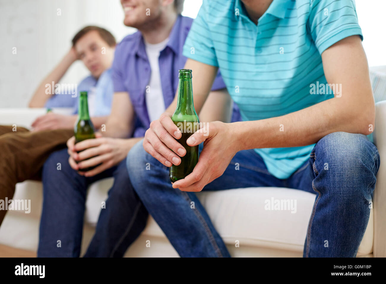 happy male friends drinking beer at home Stock Photo - Alamy