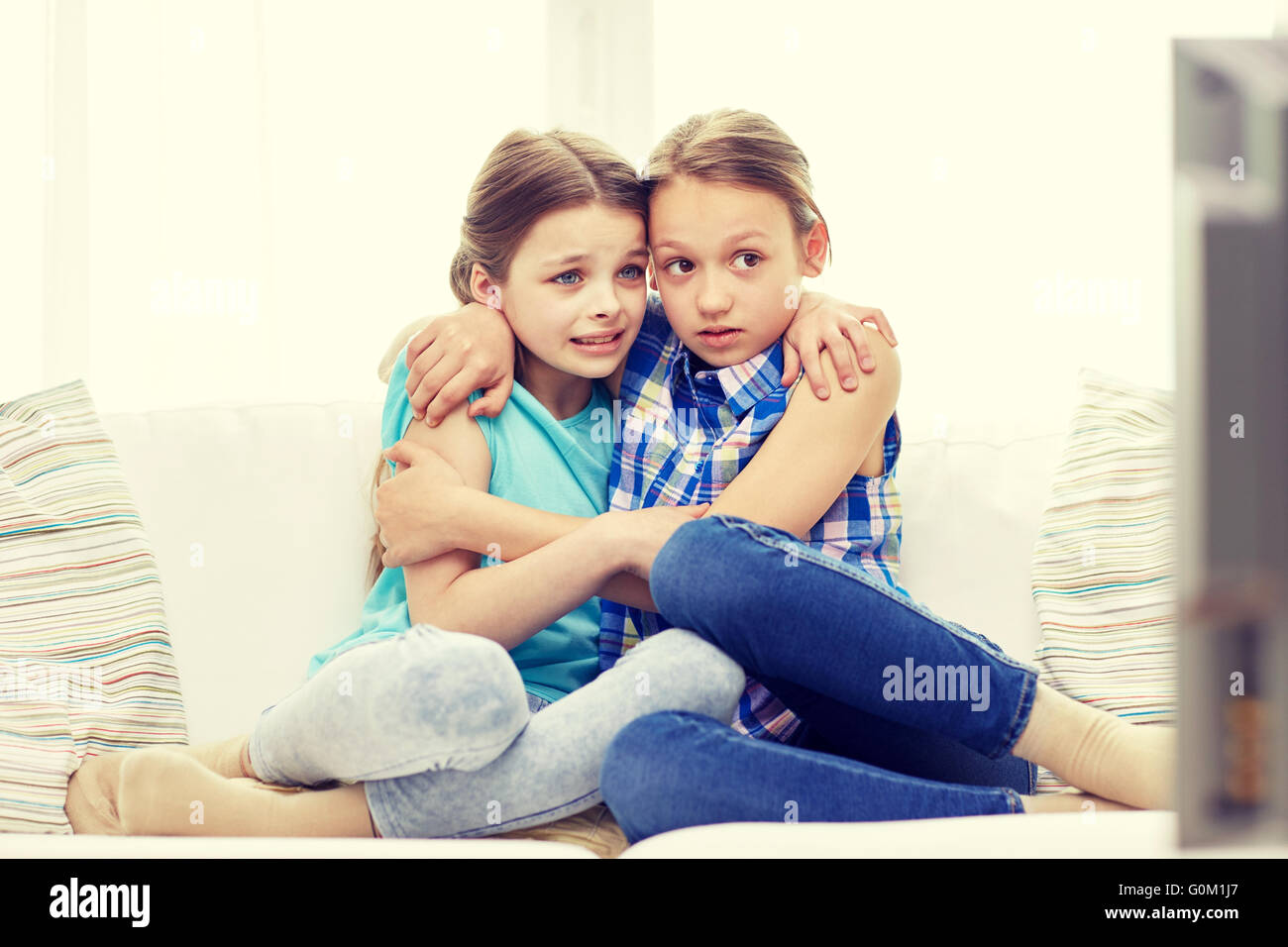 scared little girls watching horror on tv at home Stock Photo - Alamy