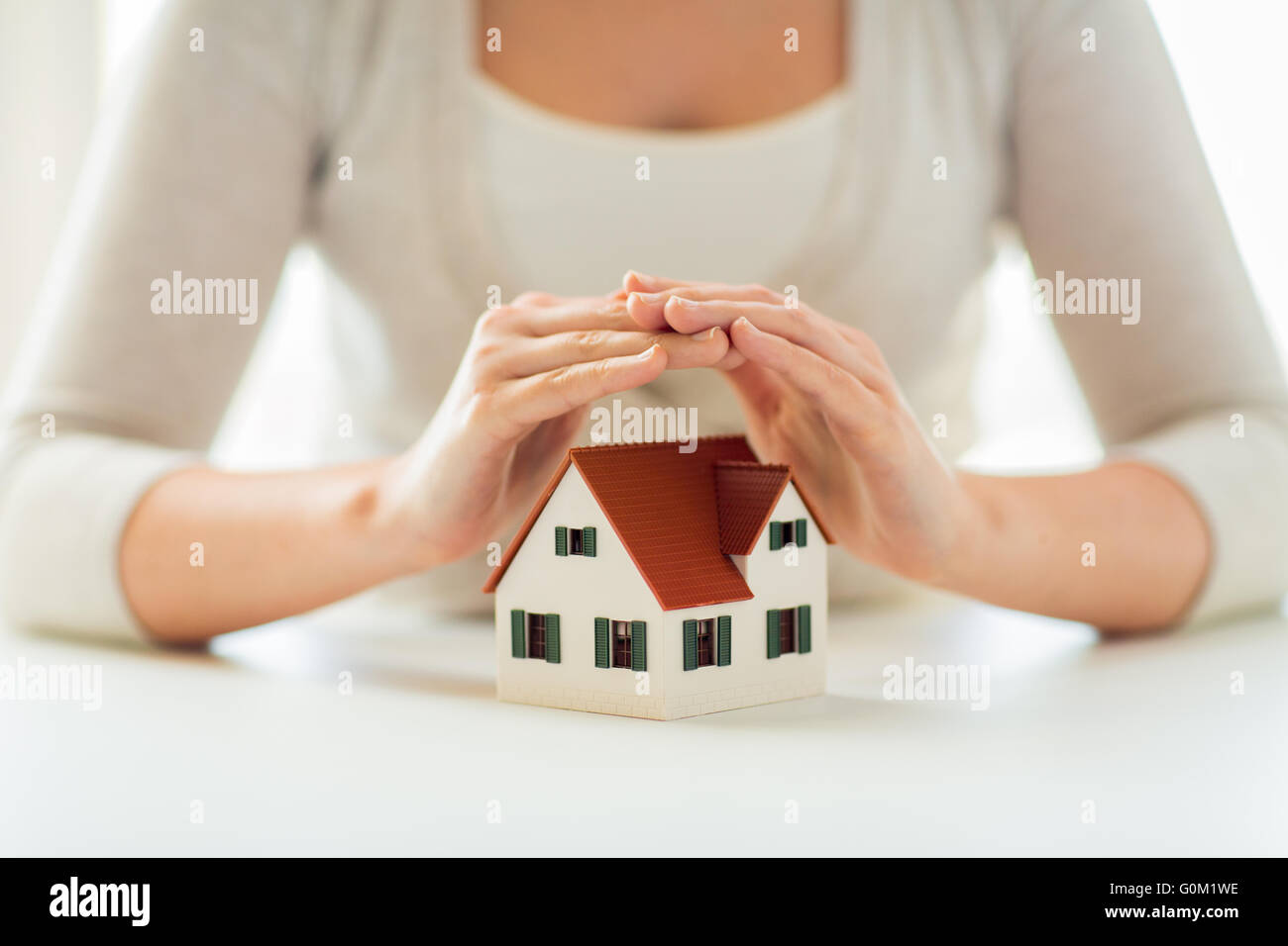 close up of hands protecting house or home model Stock Photo - Alamy