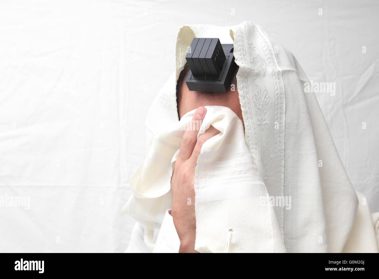 Jewish Man wrapped in tefillin pray . A religious orthodox Jew with arm ...