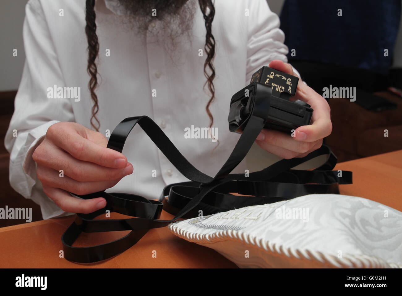 Jewish Man wrapped in tefillin pray . A religious orthodox Jew with arm ...