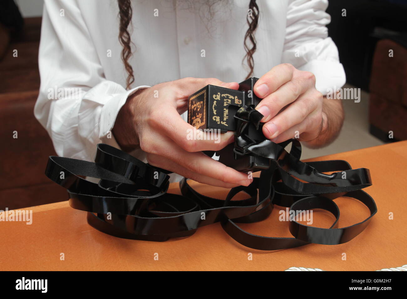 Jewish Man wrapped in tefillin pray . A religious orthodox Jew with arm ...