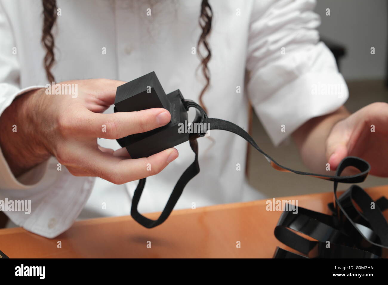 Jewish Man wrapped in tefillin pray . A religious orthodox Jew with arm ...